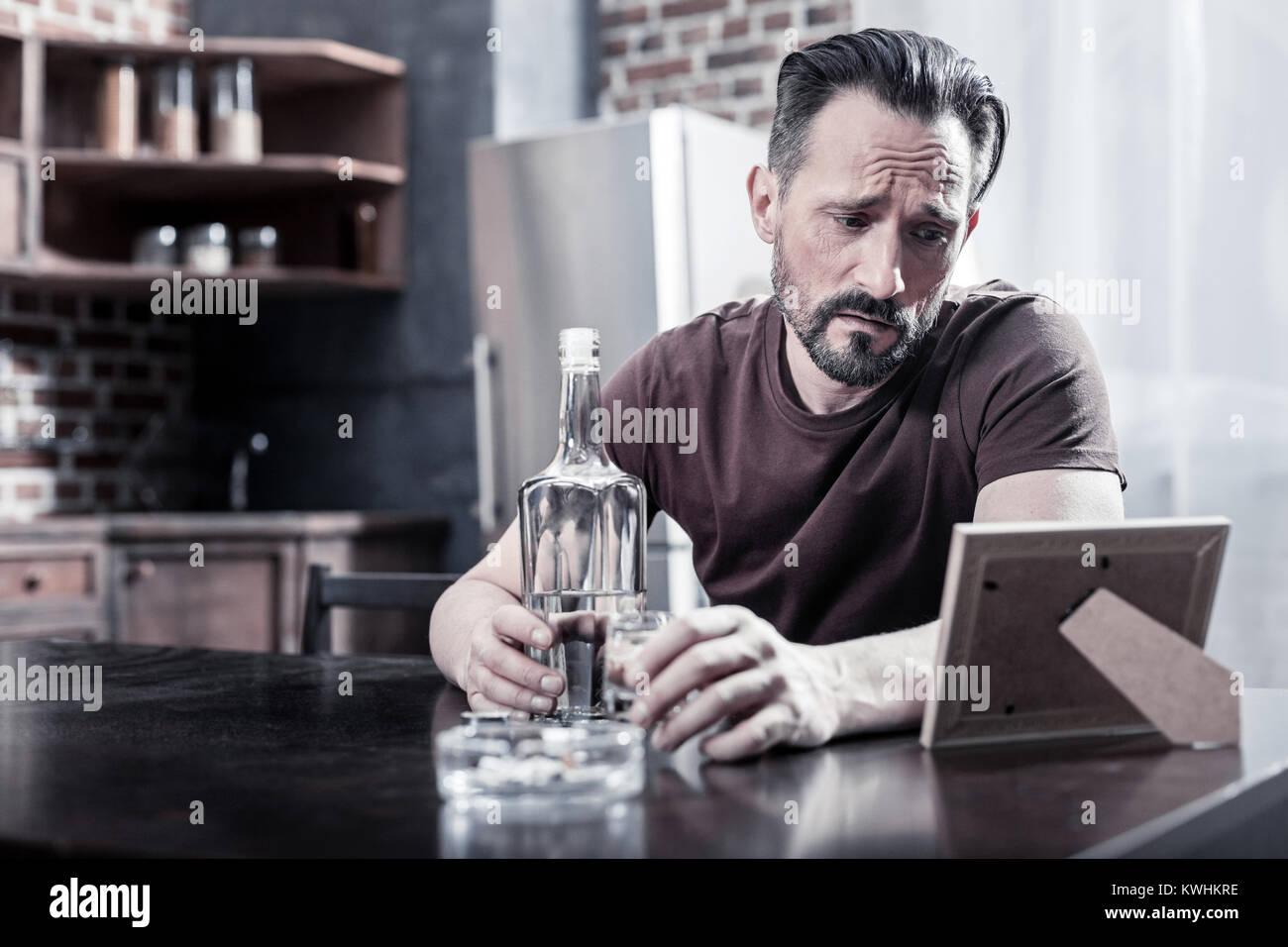 Sad gloomy man looking at the photo Stock Photo - Alamy
