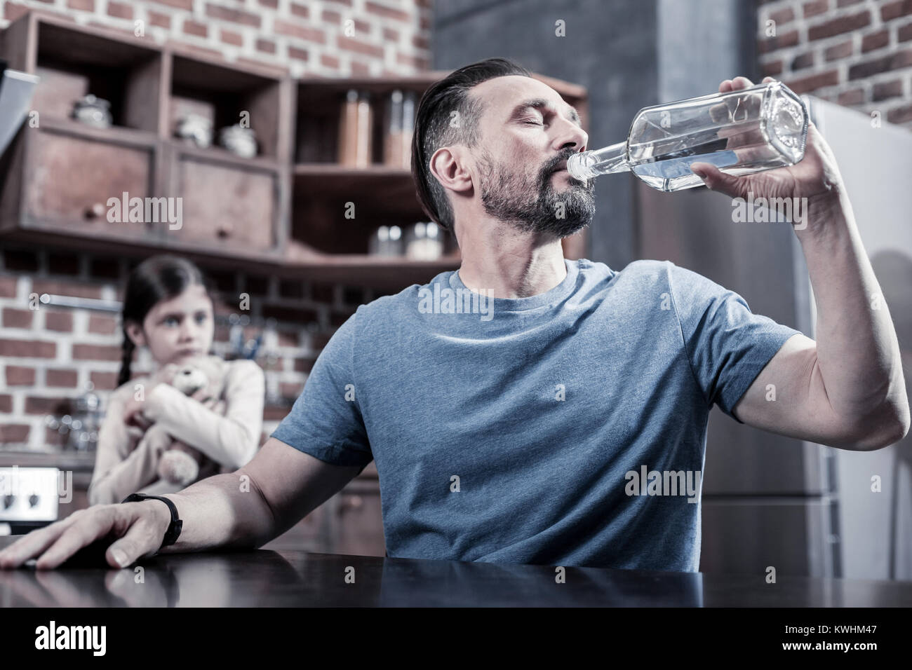 Sad depressed man sitting in the kitchen Stock Photo - Alamy