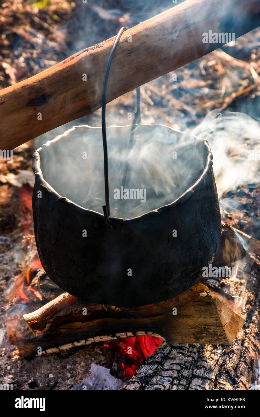 cauldron in steam and smoke on open fire. outdoor cooking concept. old ...