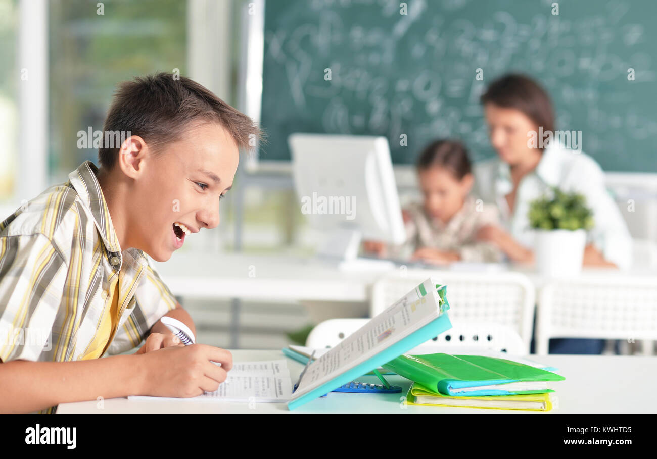 Pupil studying lessons in computer class with blurred teacher and ...