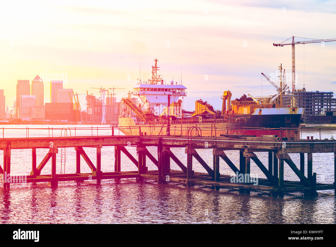 Sunset casting a pink light on a disused jetty adjacent to the Thames ...