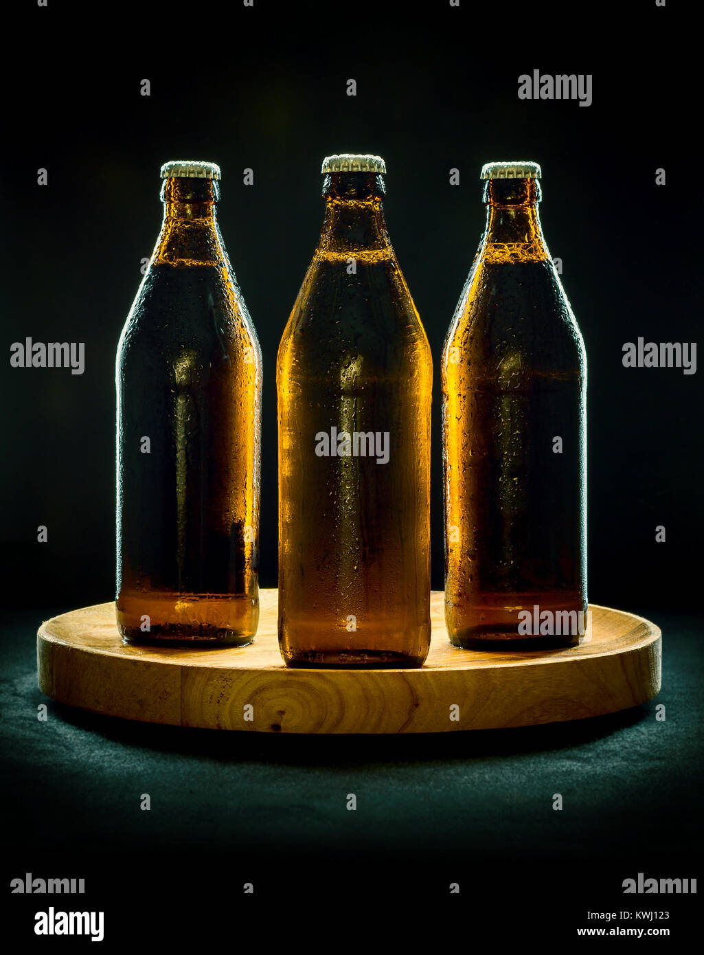 Three cool beer bottles on wooden tray and black background Stock Photo ...