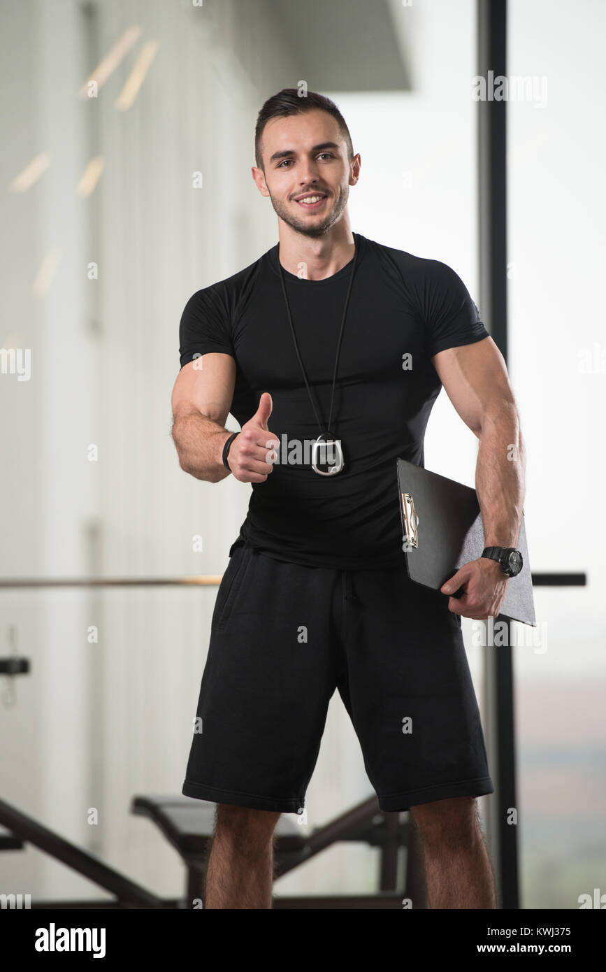 Handsome Personal Trainer With A Clipboard In Fitness Center Gym Stock ...