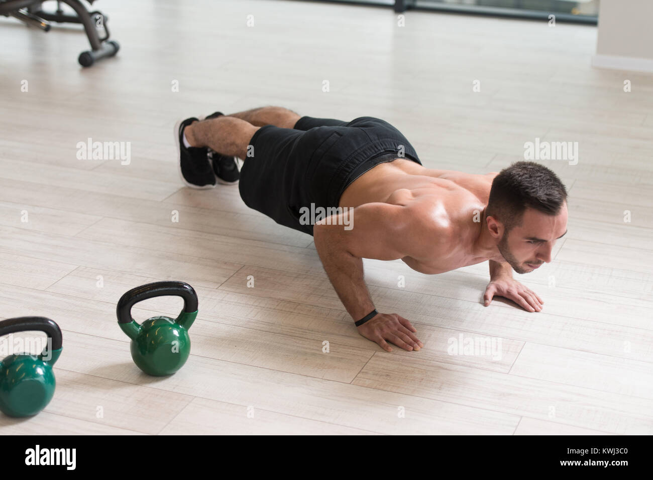 Healthy Man Athlete Doing Pushups Workout With Kettle Bell In A Gym ...