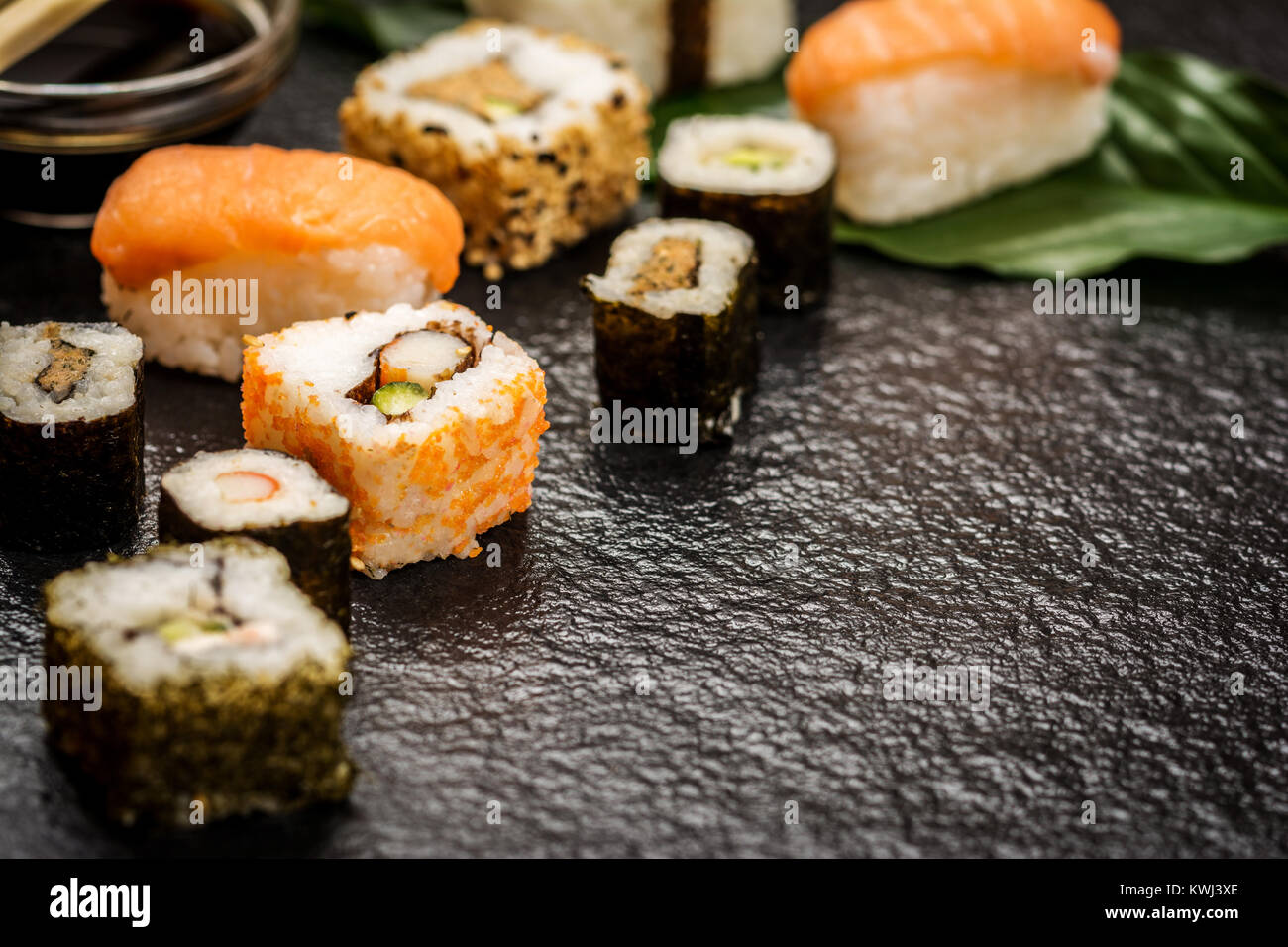 Traditional japanese sushi rolls hosomaki,uramaki, nigiri on stone desk ...