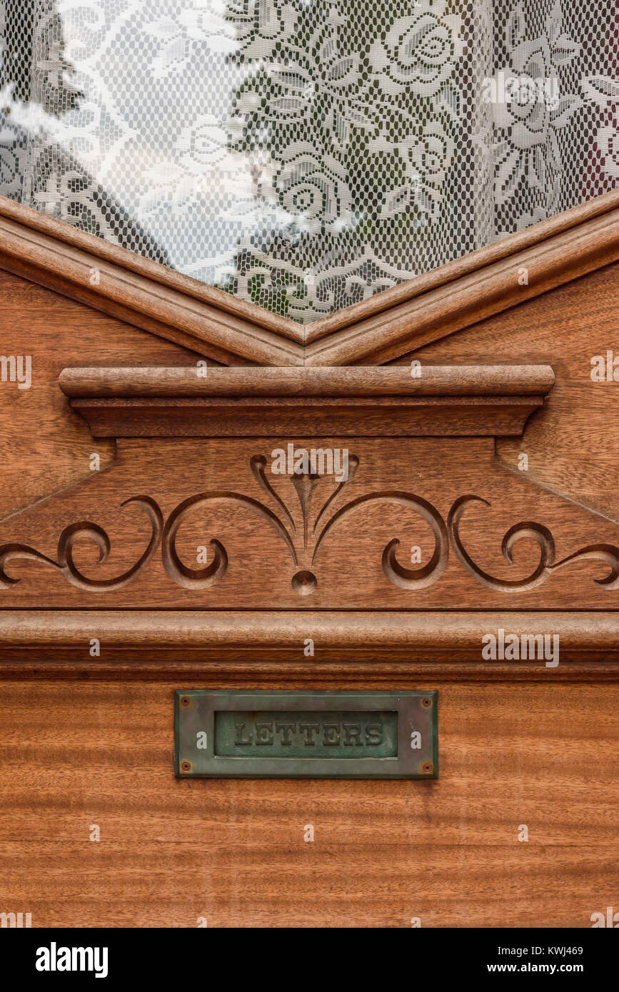 detail of old victorian wood carved door with lace curtain and patina ...