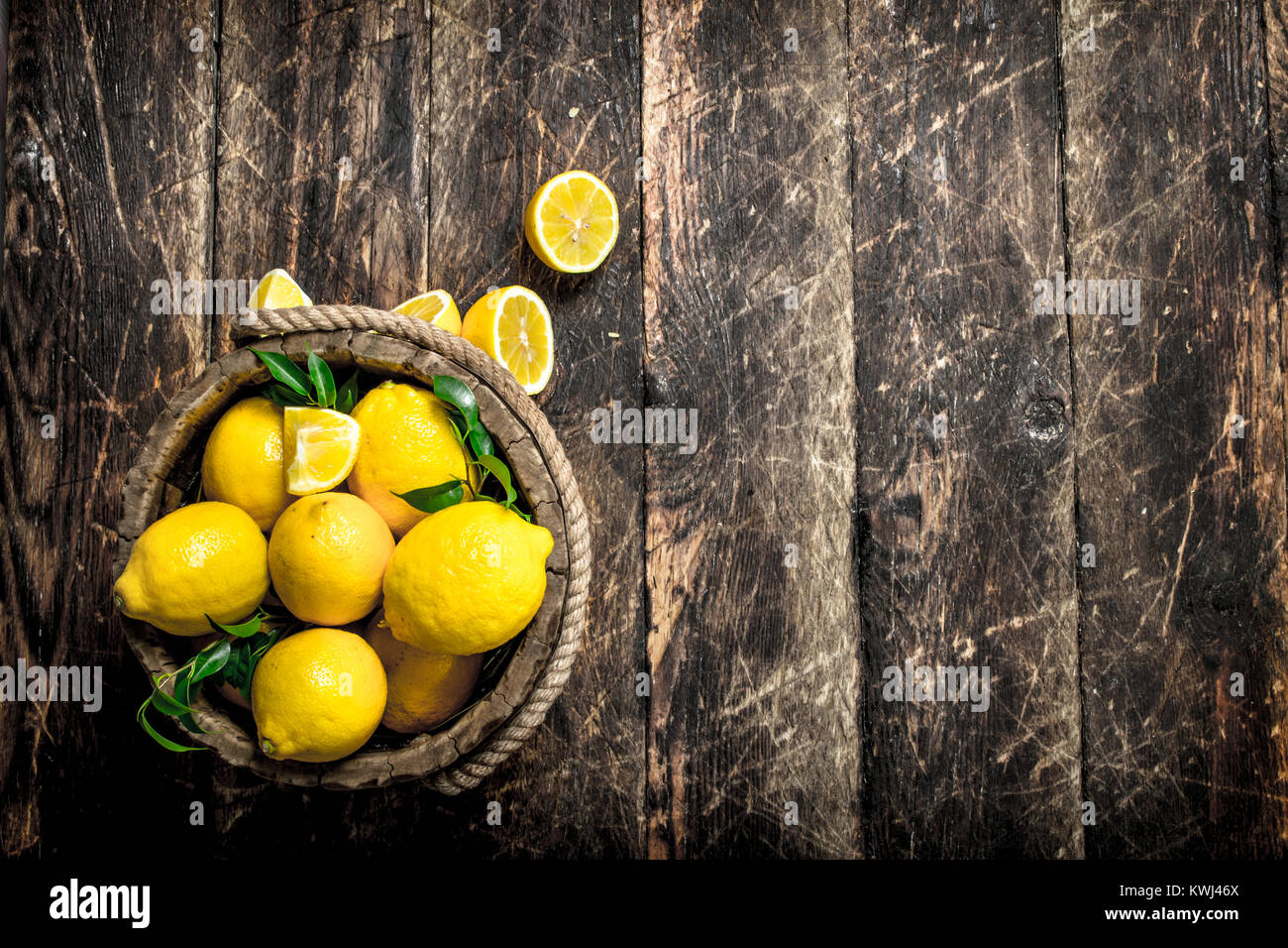 Fresh lemons in a wooden bucket. On a wooden background Stock Photo - Alamy