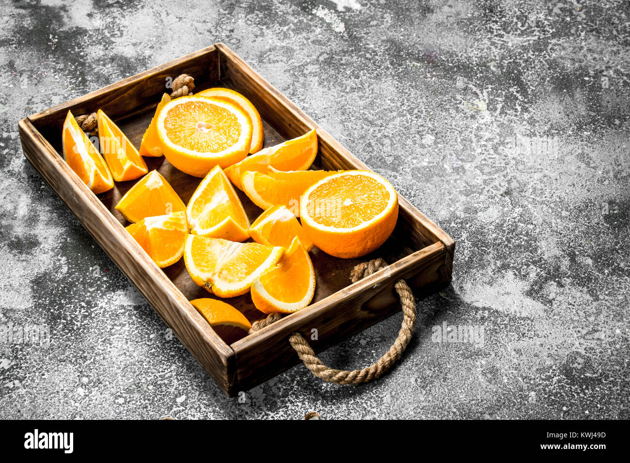 Fresh slices of oranges in a wooden tray. On a rustic background Stock ...
