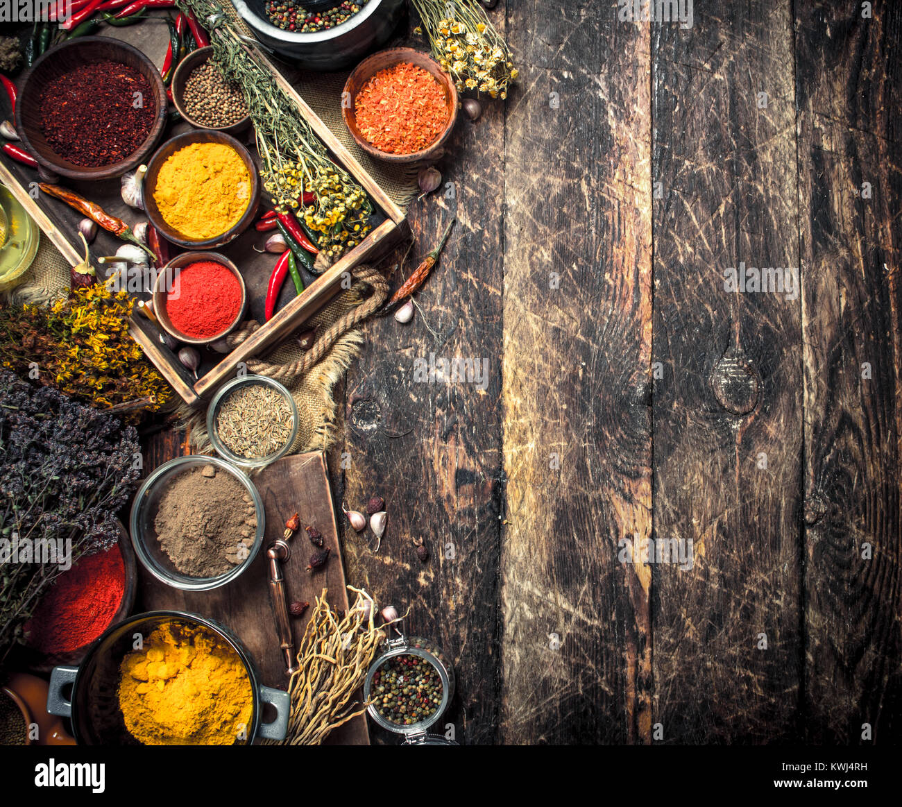 Various ground spices and herbs in an old tray. On a wooden background ...