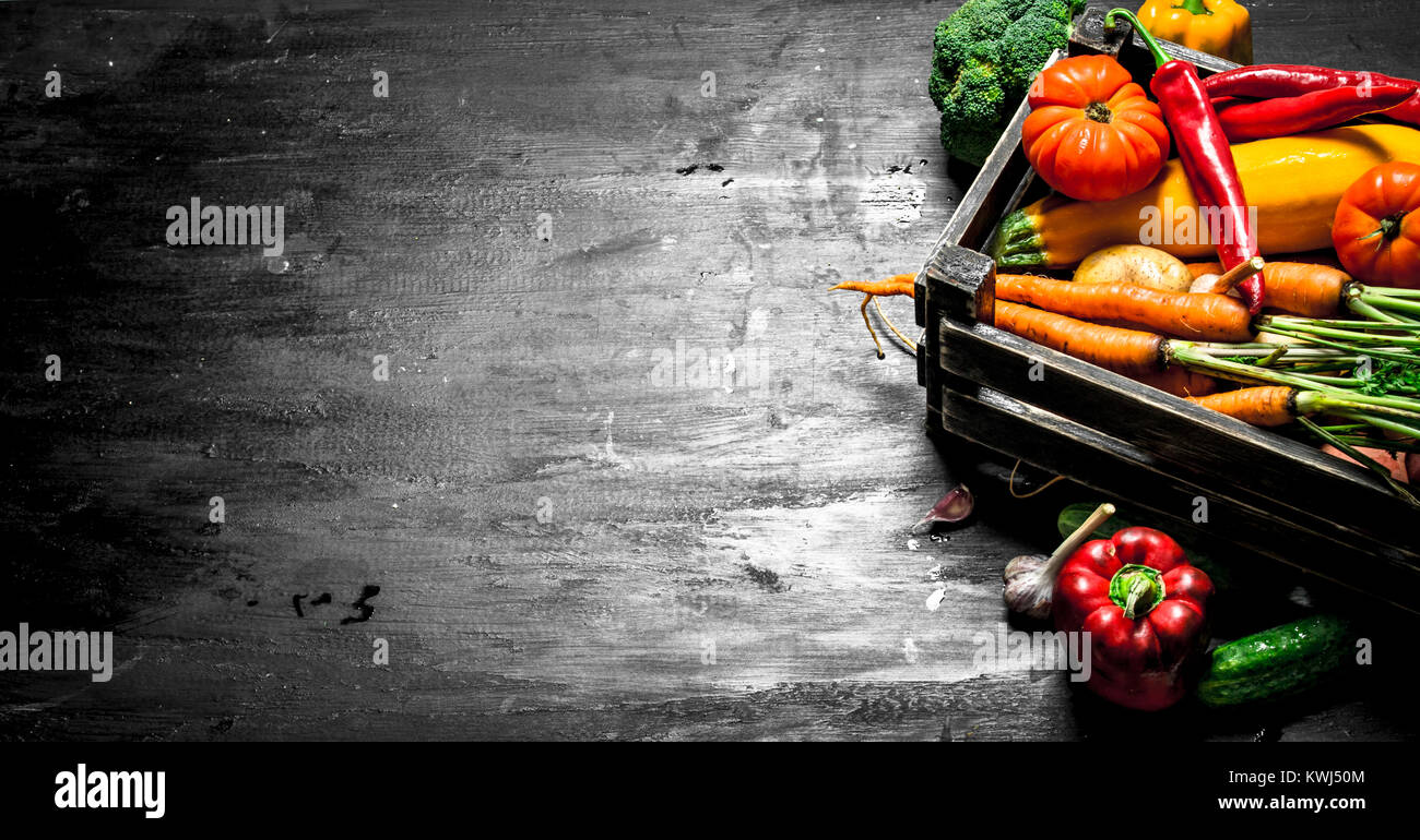 Organic food. Fresh vegetables in an old box. On the black chalkboard ...