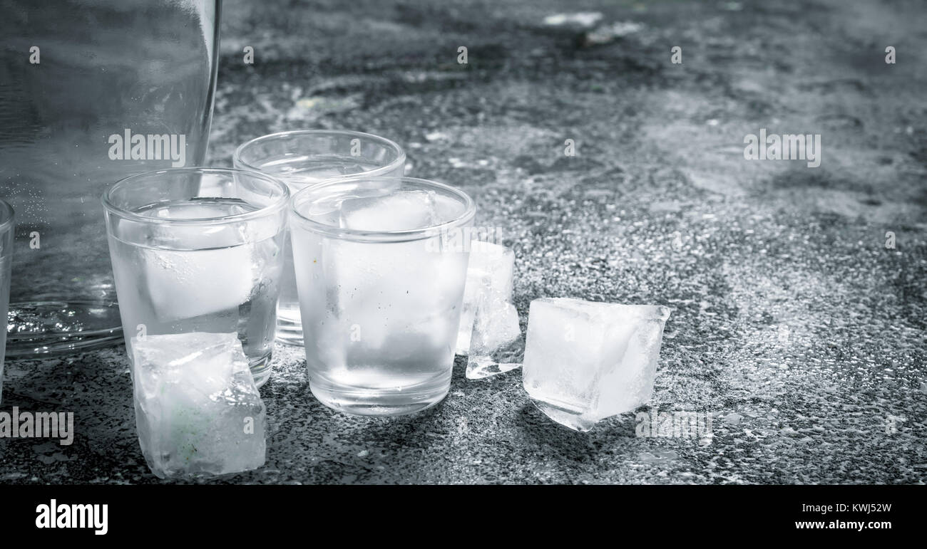 Vodka with ice in glasses. On a rustic background Stock Photo - Alamy