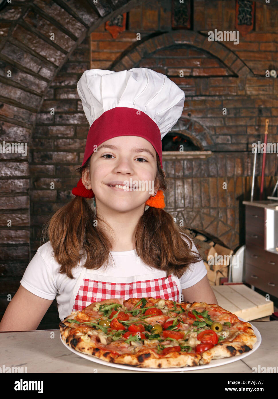 happy little girl cook with pizza in pizzeria Stock Photo - Alamy