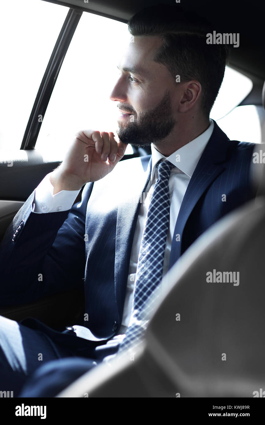 Smiling business man sitting in the back seat of a car Stock Photo - Alamy