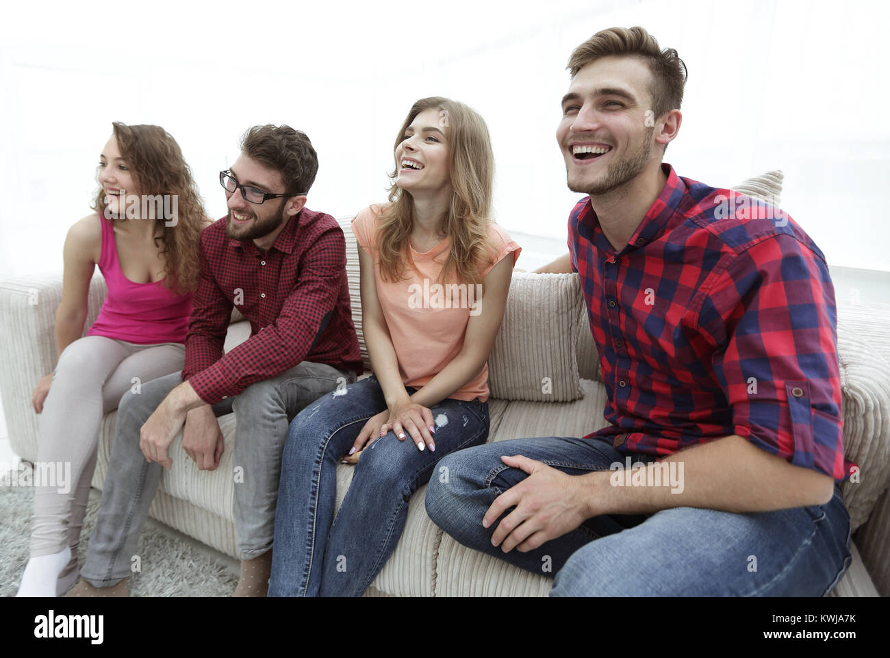 group of smiling young people sitting on the couch Stock Photo - Alamy