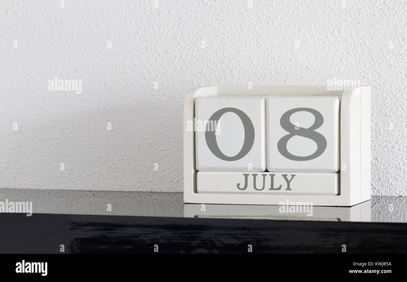 White block calendar present date 8 and month July on white wall ...