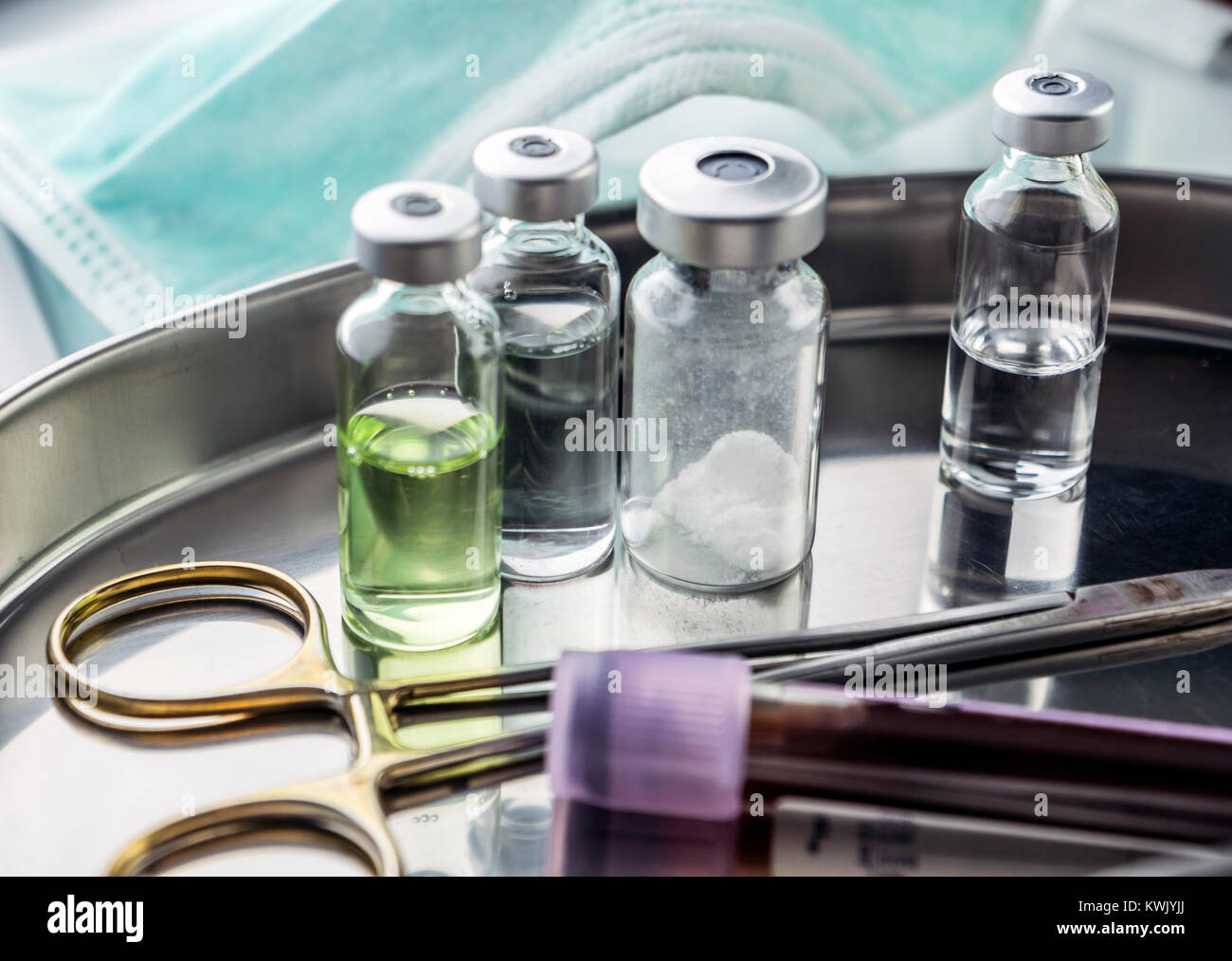 Scissors and vials of blood samples in a tray on a table of a hospital ...