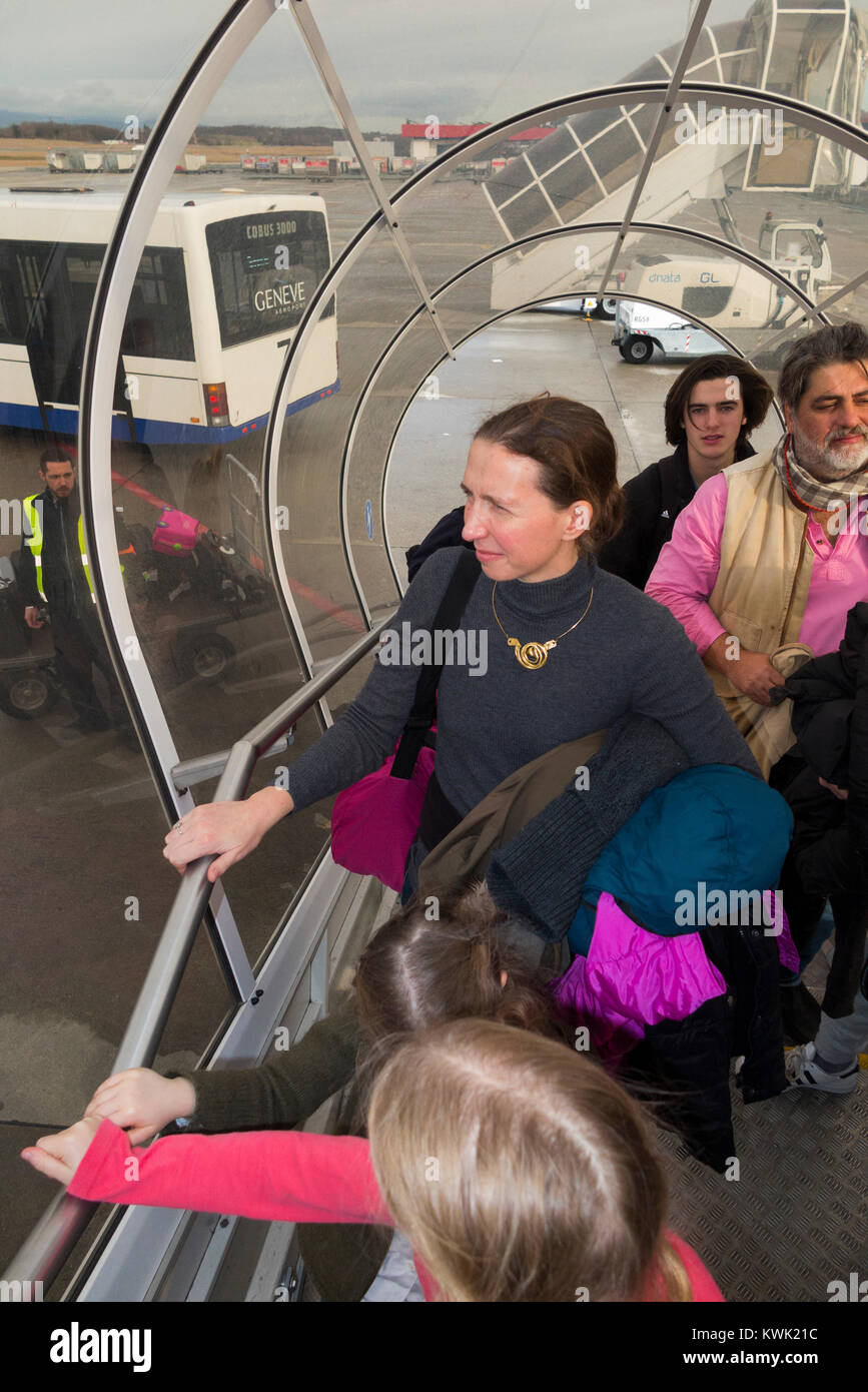 Mother with children board / boarding an aeroplane / climbing the steps ...