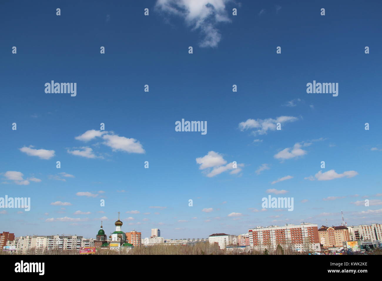 Blue clear day sky with white clouds and sunlight. A city landscape ...