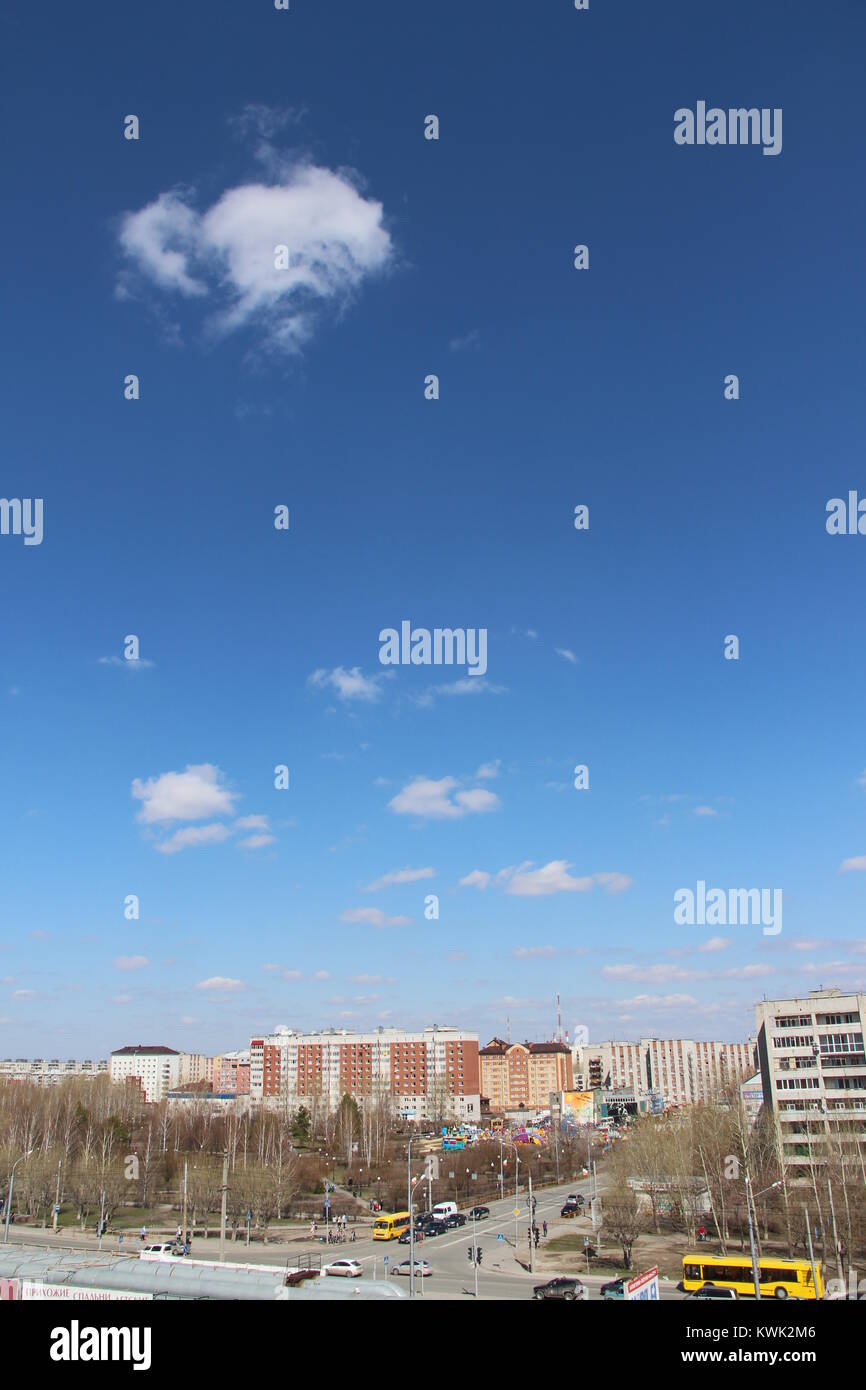 Blue clear day sky with white clouds and sunlight. A city landscape ...