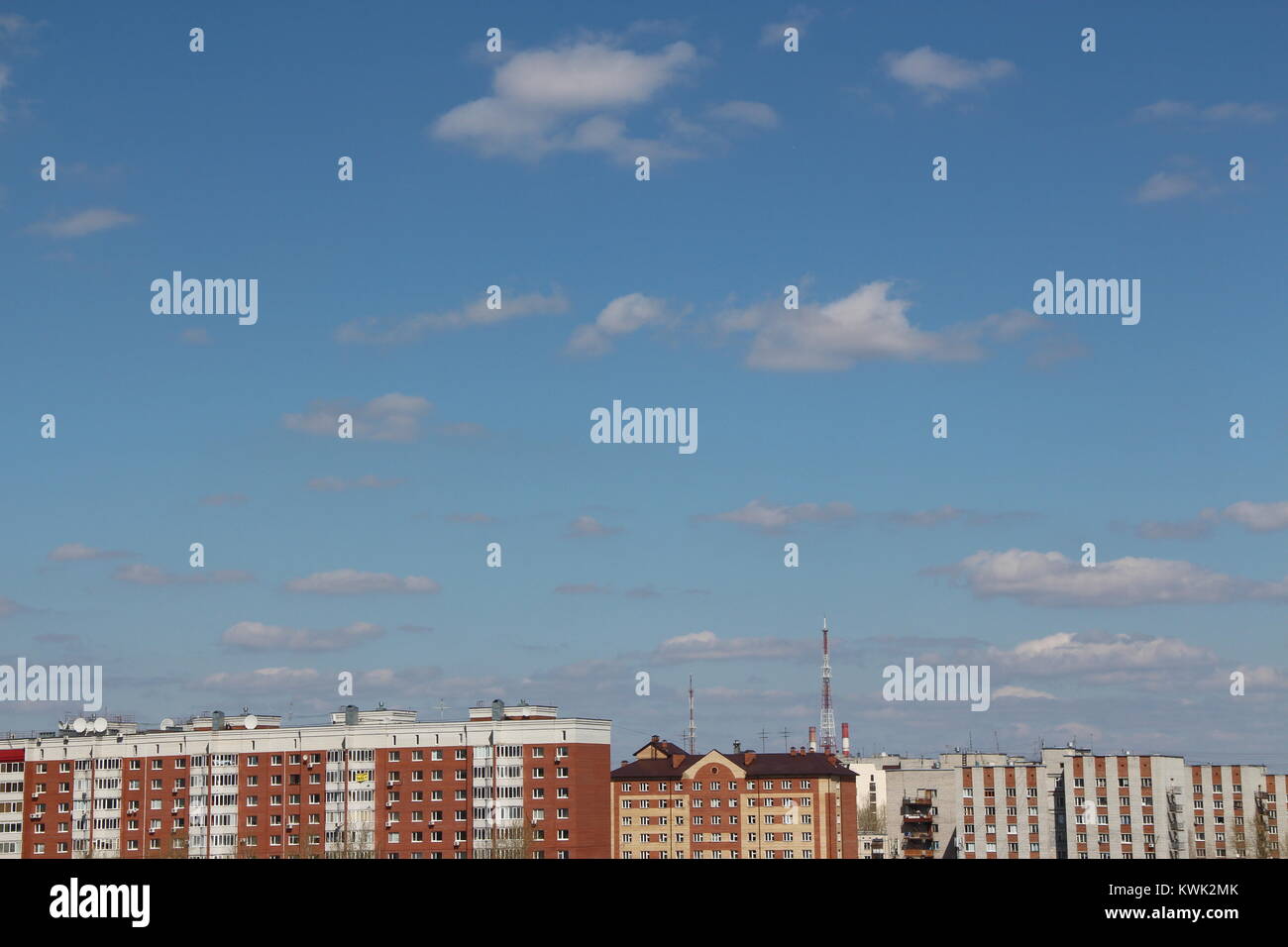 Blue clear day sky with white clouds and sunlight. A city landscape ...