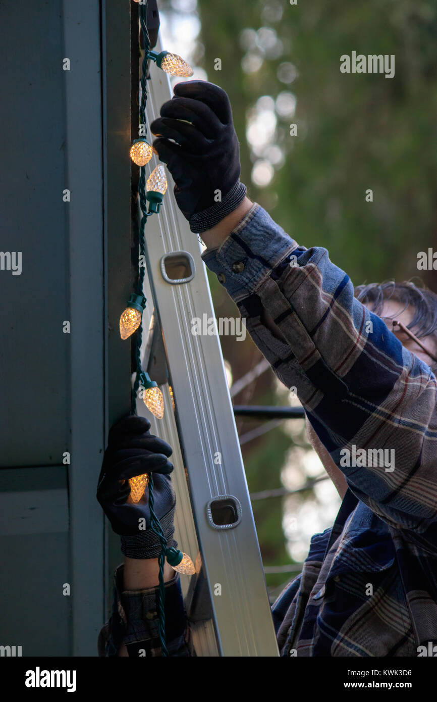 man in gloves decorates a home from a ladder Stock Photo - Alamy