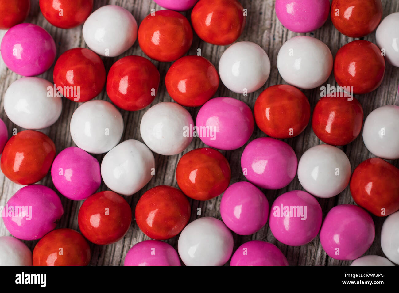 Red white and pink candy arranged on a white painted board Stock Photo ...