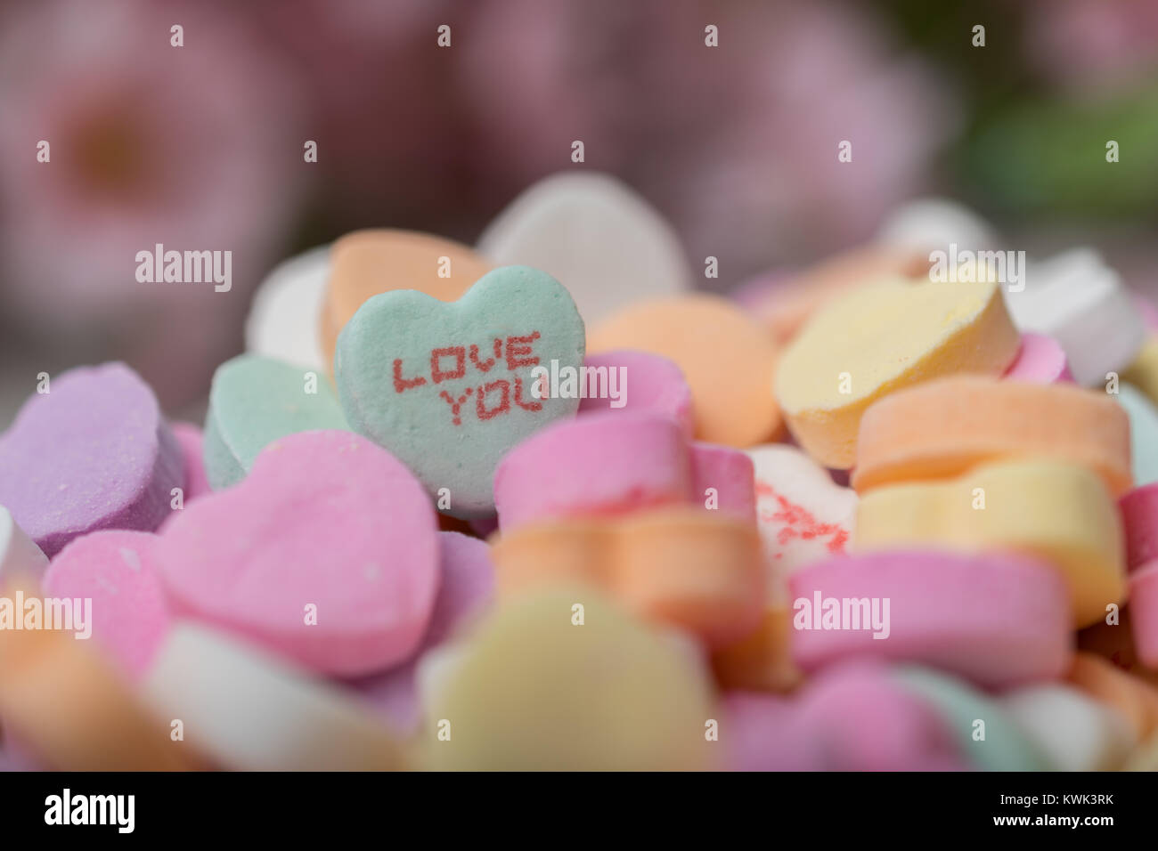 Bowl of valentines heart candy with messages. Focus is on Love You ...