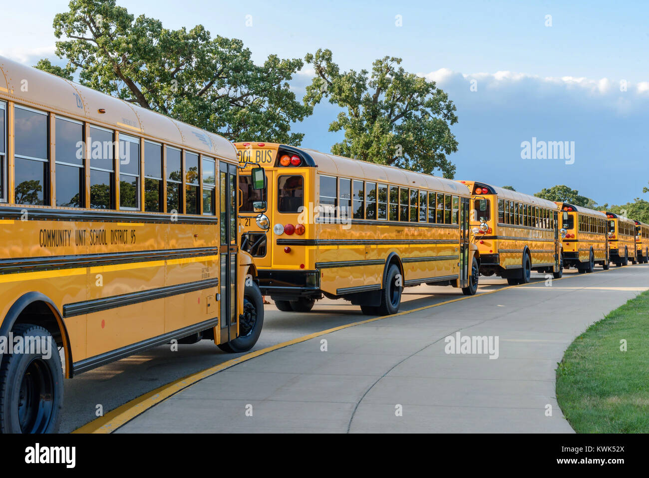 line of yellow school buses along curved drive outside of school Stock ...