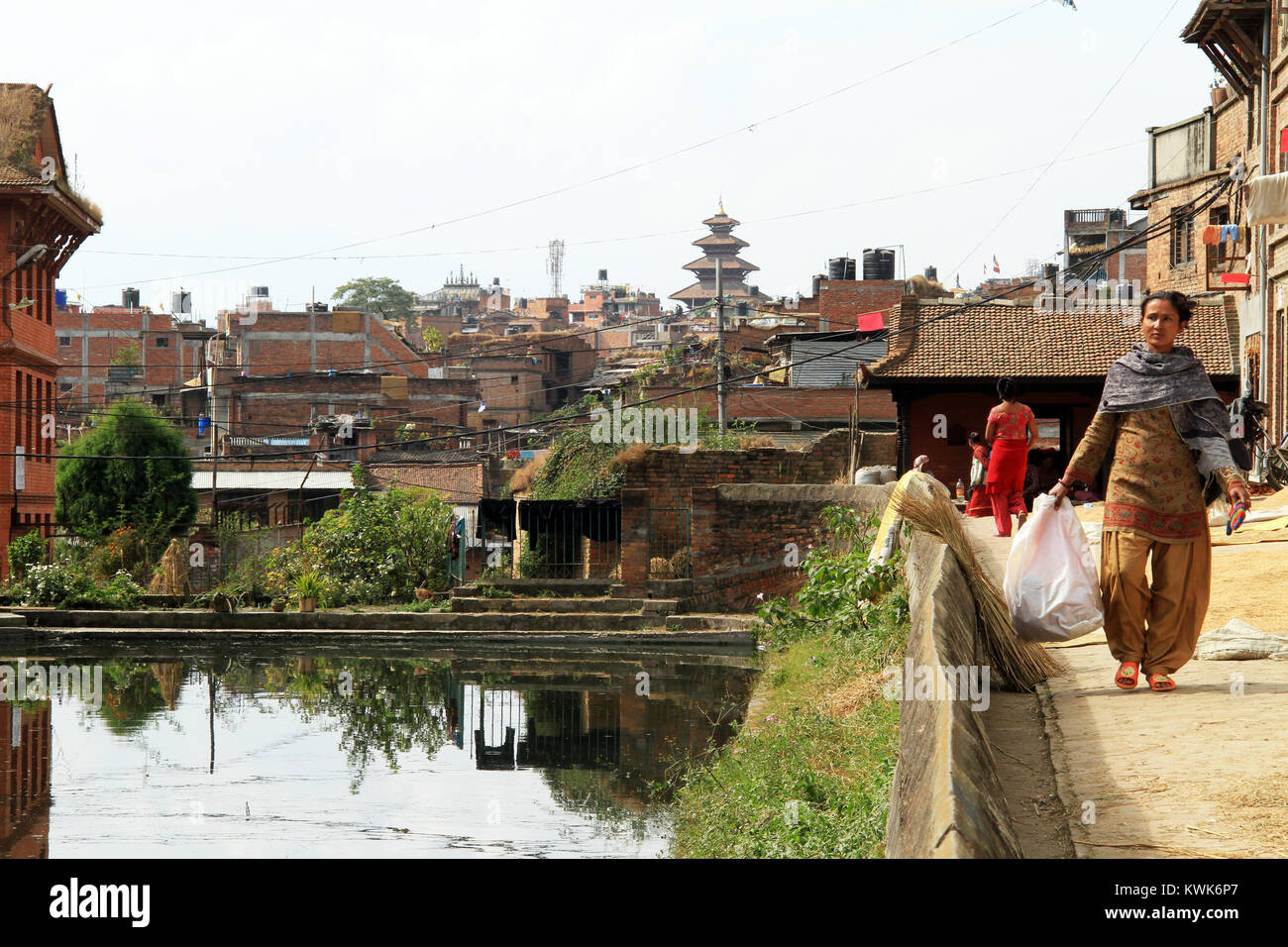 BHAKTAPUR, NEPAL - CIRCA NOVEMBER 2013 Woman walk near pond Stock Photo - Alamy