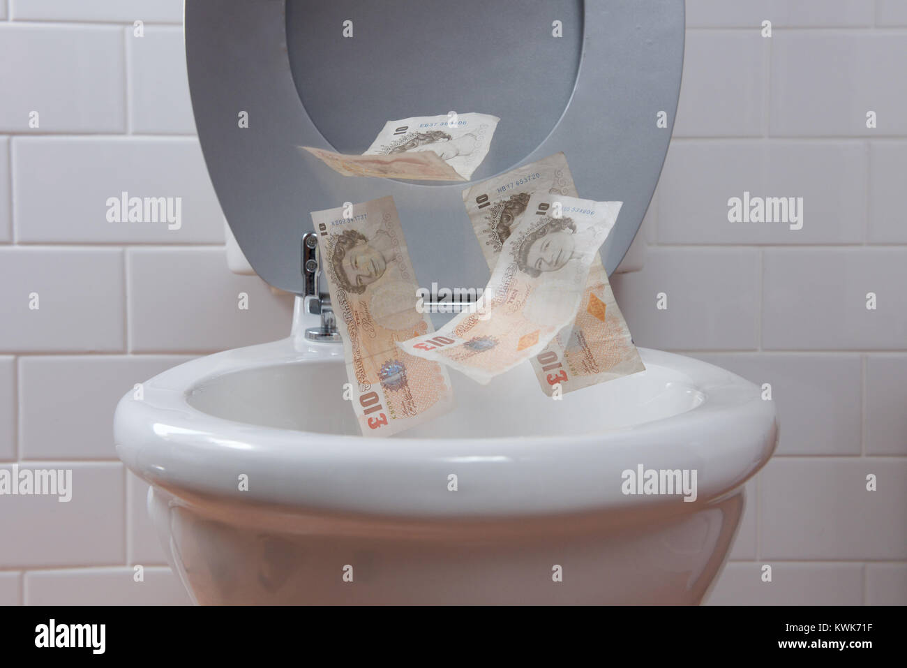 Concept -throwing your money down the toilet Stock Photo - Alamy