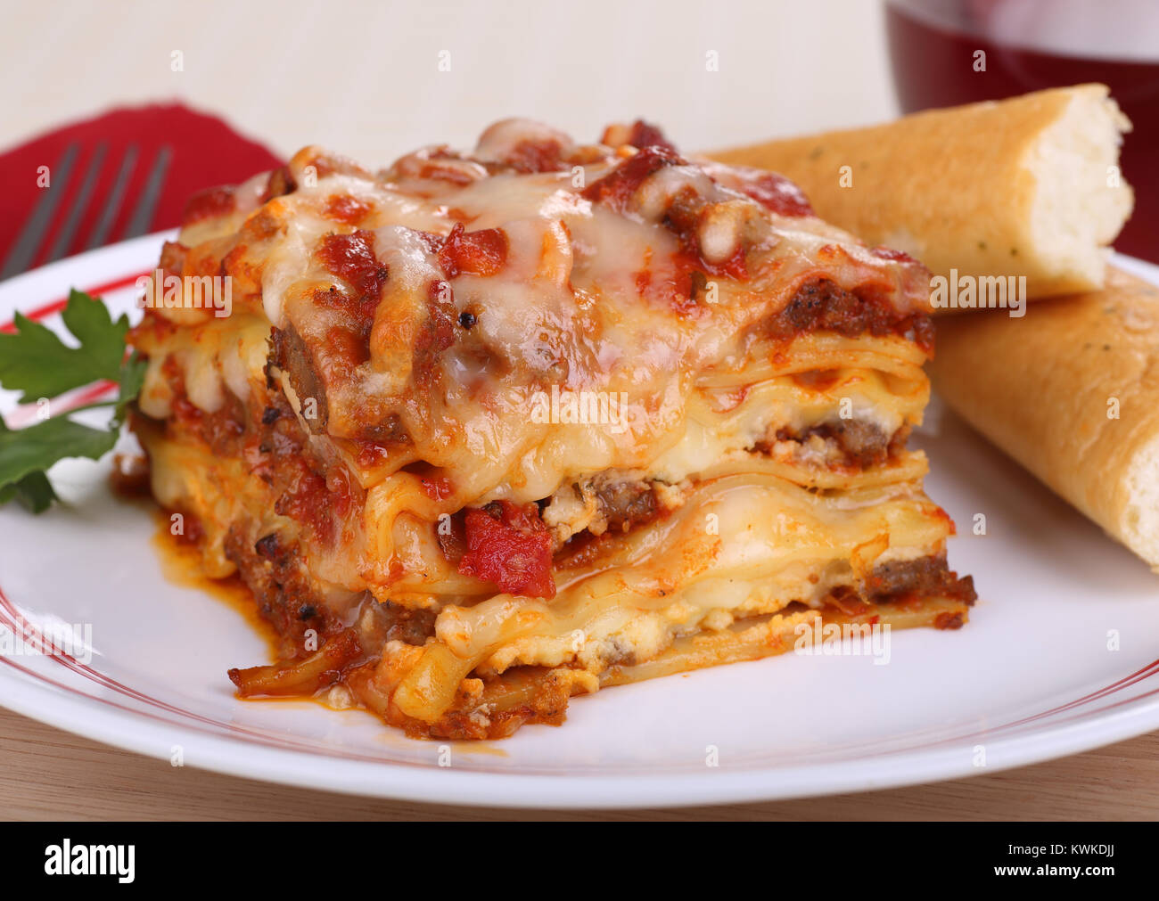 Slice of lasagna with bead sticks on a plate Stock Photo - Alamy