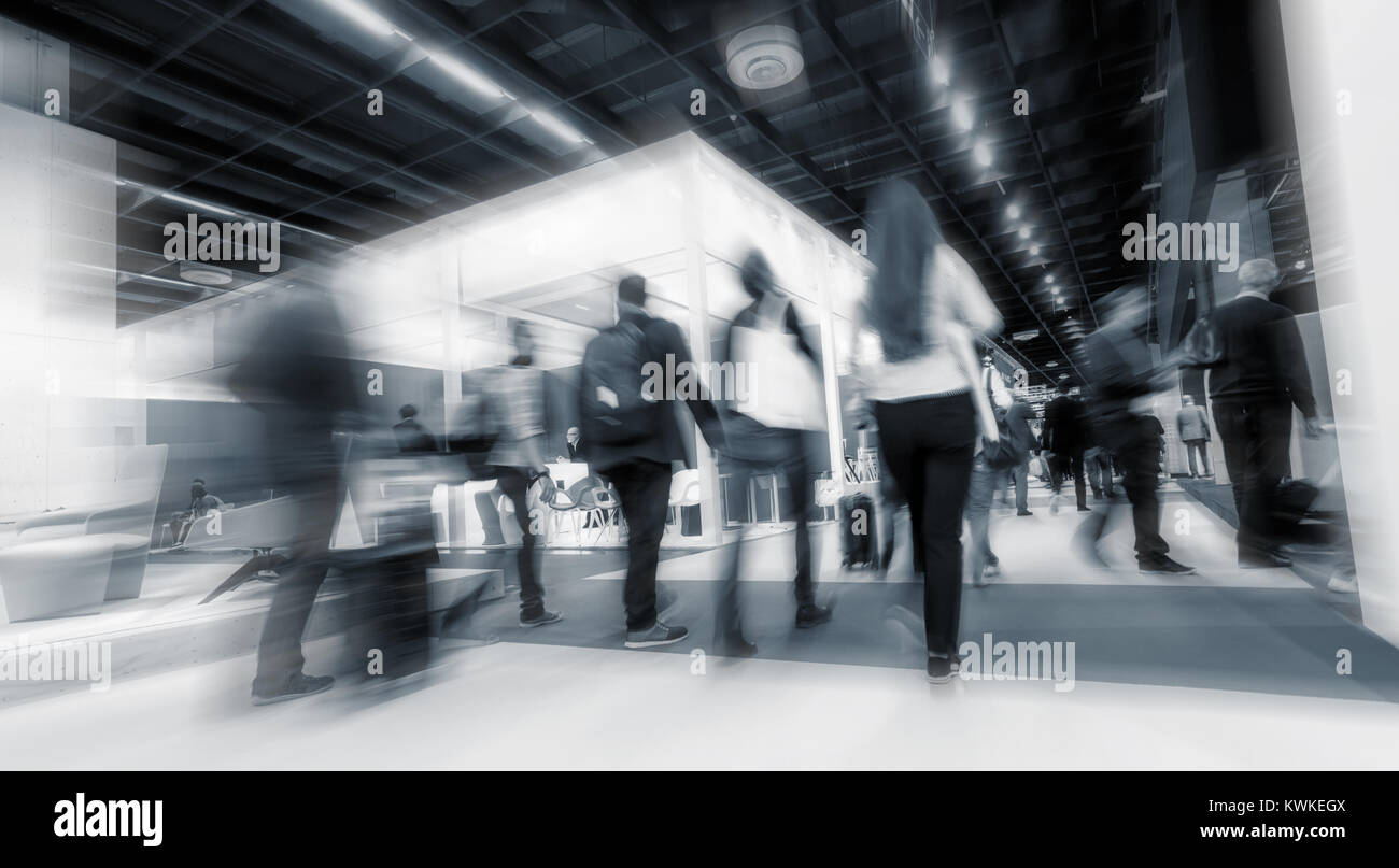 business people walking at trade show booths, abstract zoom in effect ...