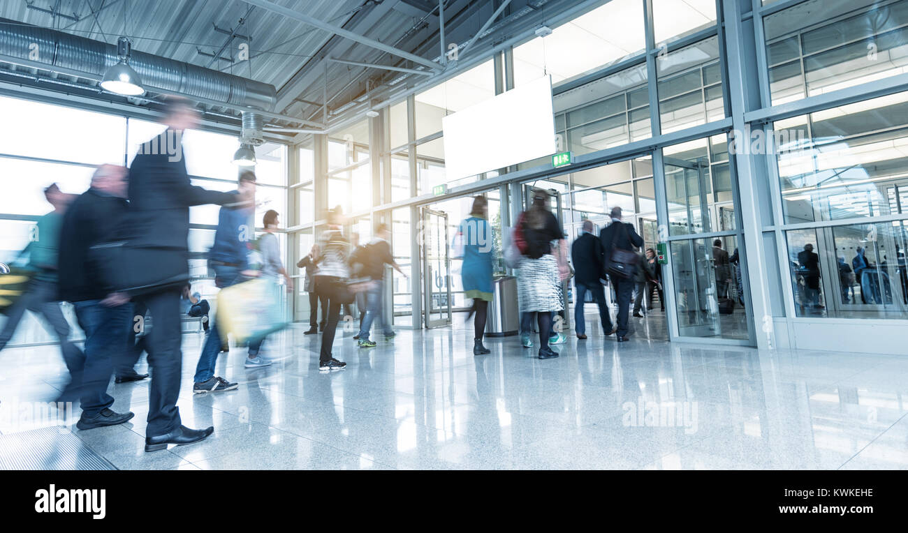 crowd of people rushing in a entrance at a trade show, including copy ...
