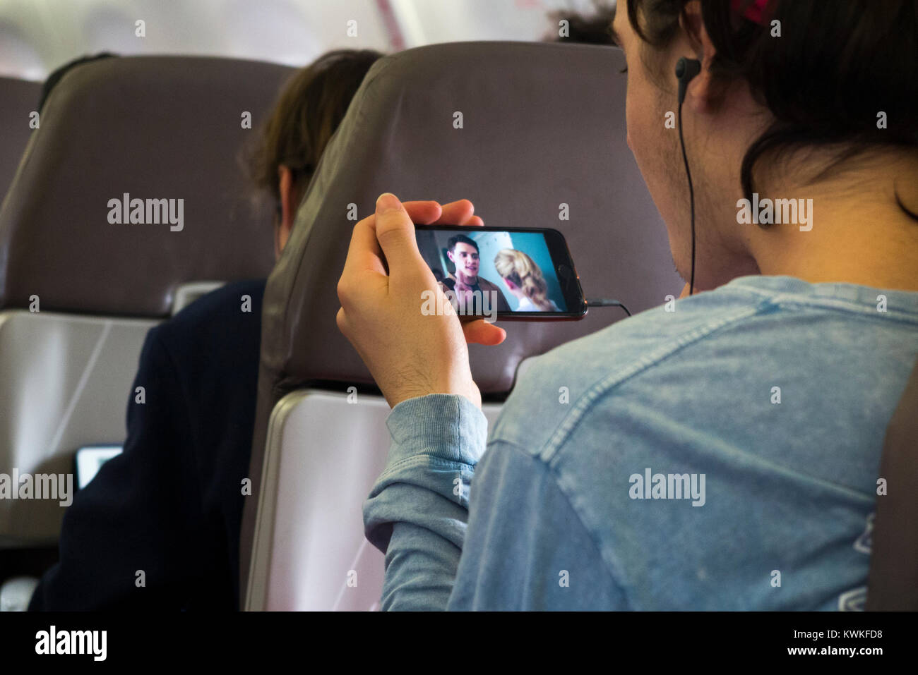Male passenger playing a show film, movie, or television programme on ...