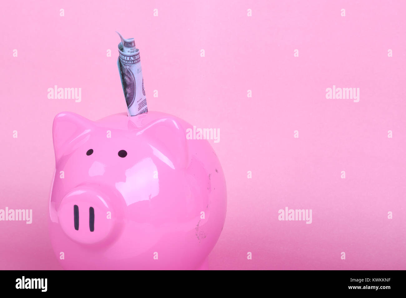 Piggy bank on soft pink background with USD dollar money banknotes ...