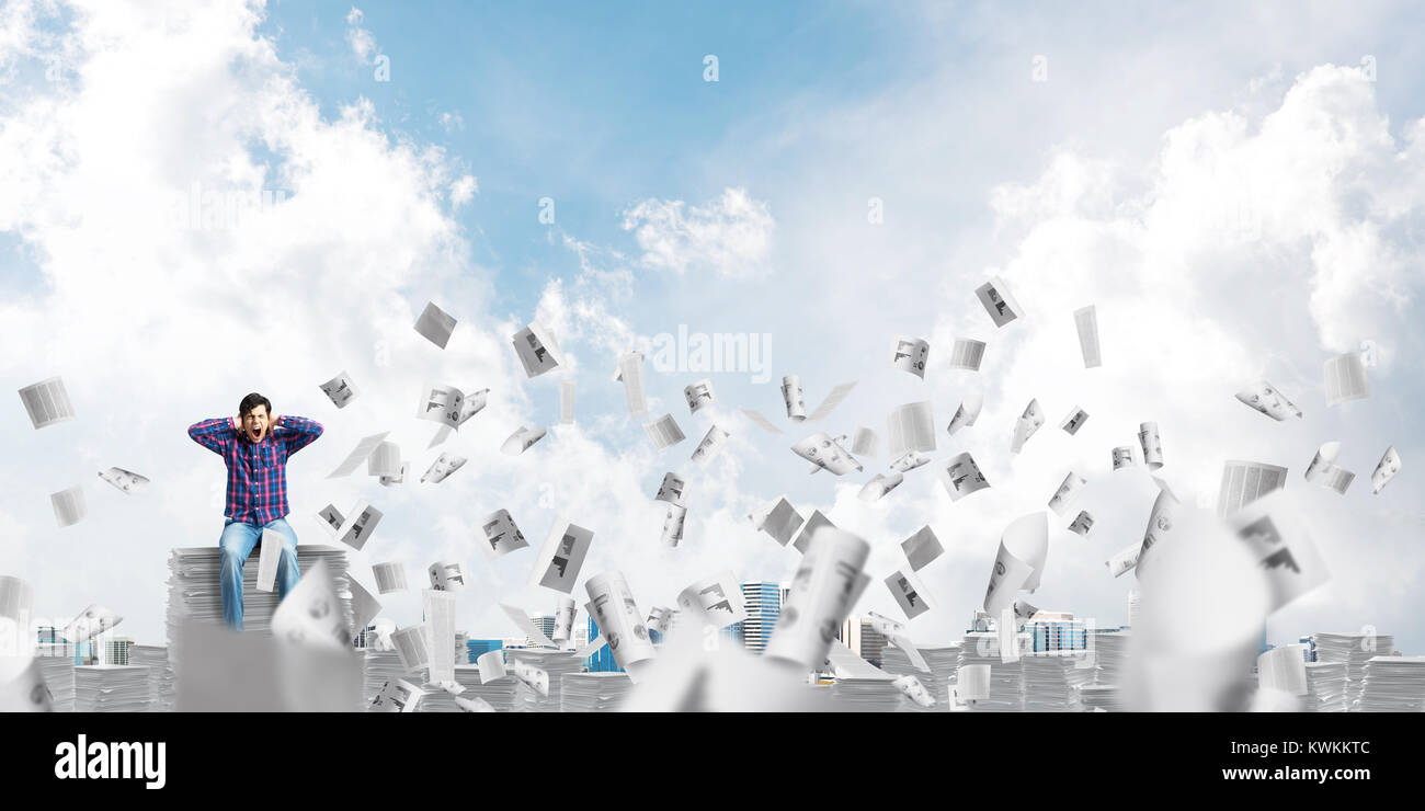 Attractive man sitting on pile of paper documents Stock Photo - Alamy