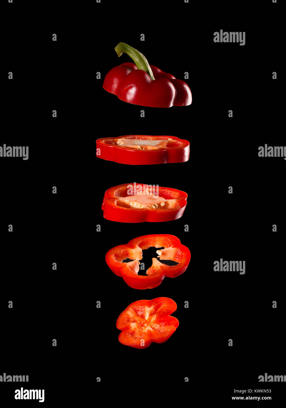 A sliced red pepper falls showing its inside structures. A concept ...