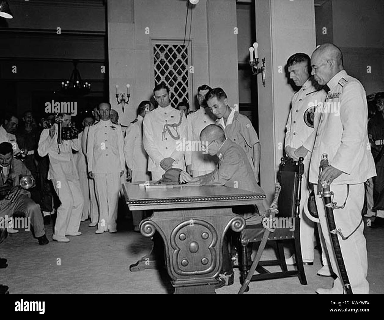 Japanese surrender ceremony. Lt. Gen. Tanaka signs surrender document ...