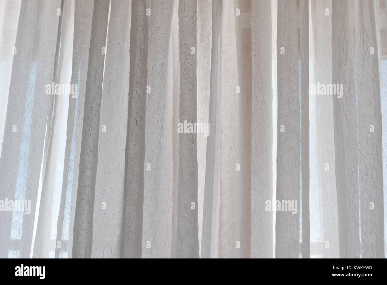 White sheers hanging gathered tightly. These are white translucent ...