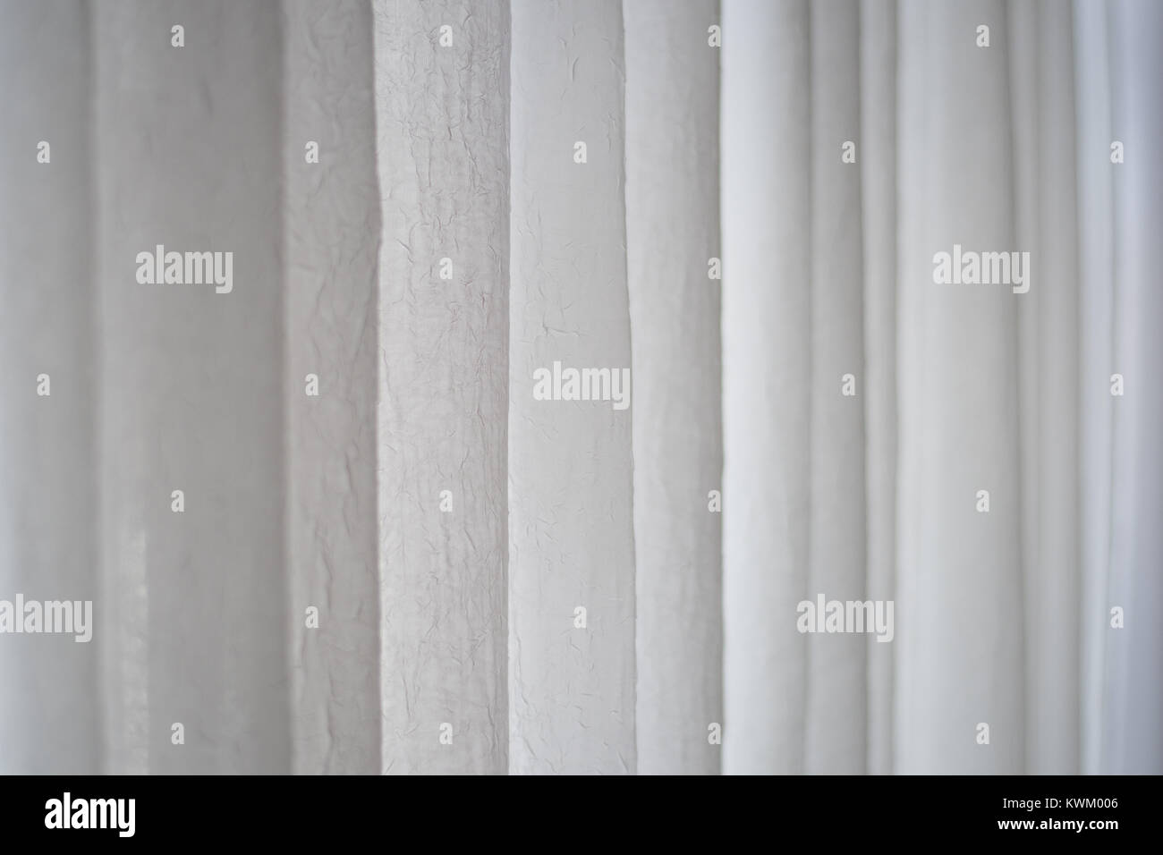 White sheers hanging gathered tightly. These are white translucent ...