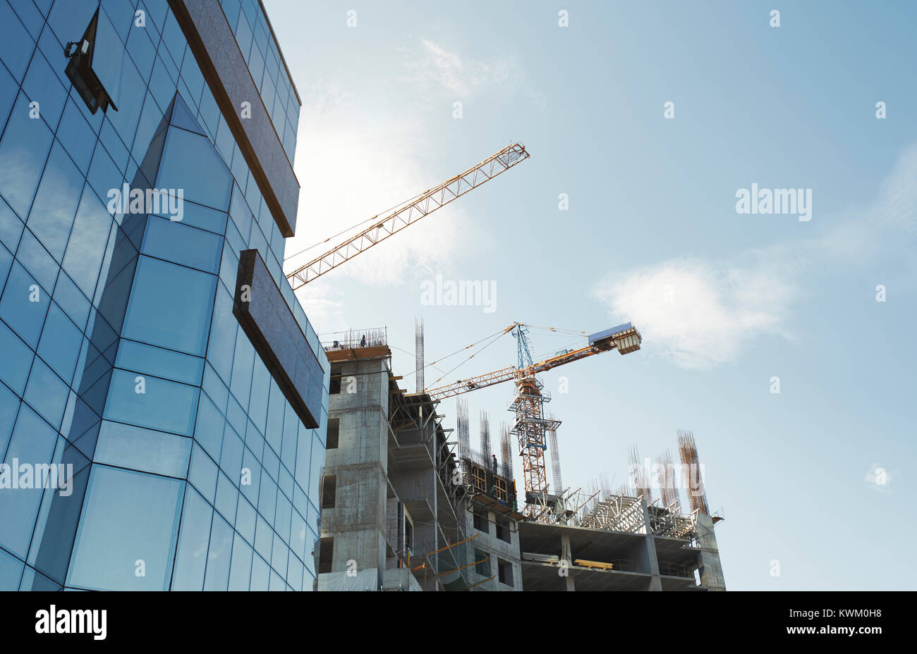 Low angle view of modern office building by construction site against ...