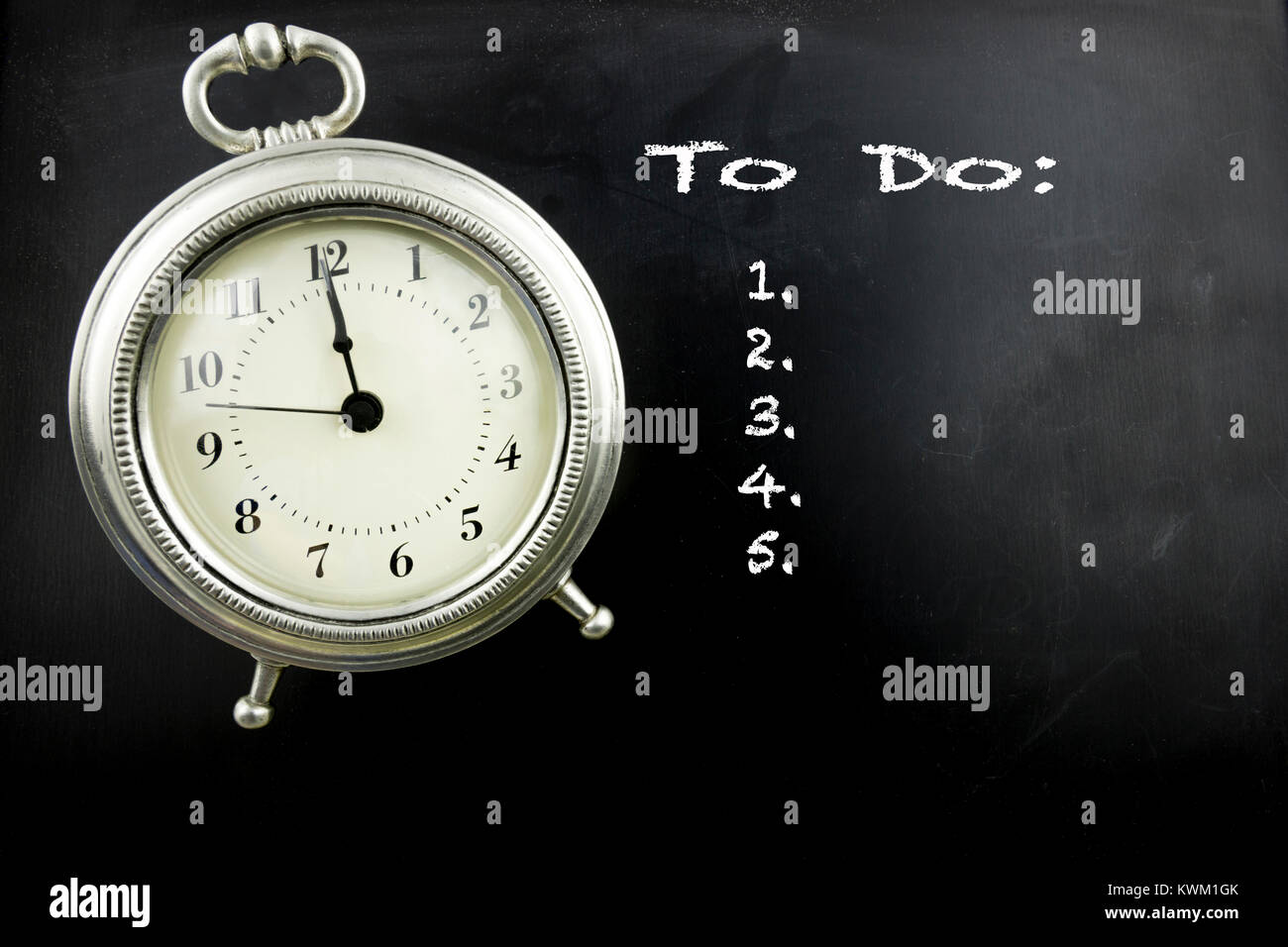 Pewter antique alarm clock on blackboard with To Do list in white chalk ...