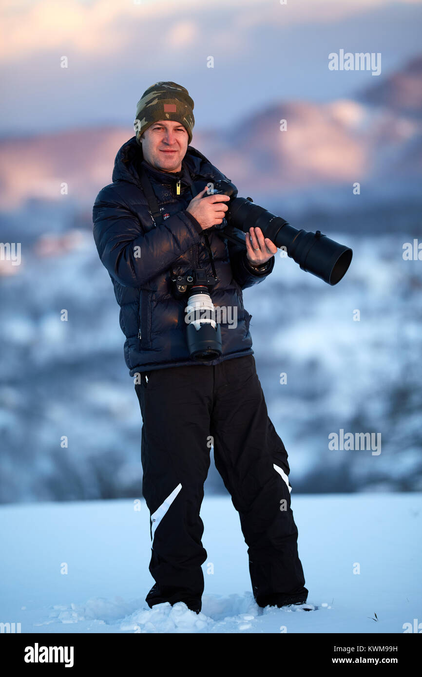 Photographer with two cameras shooting landscapes at sunset Stock Photo ...