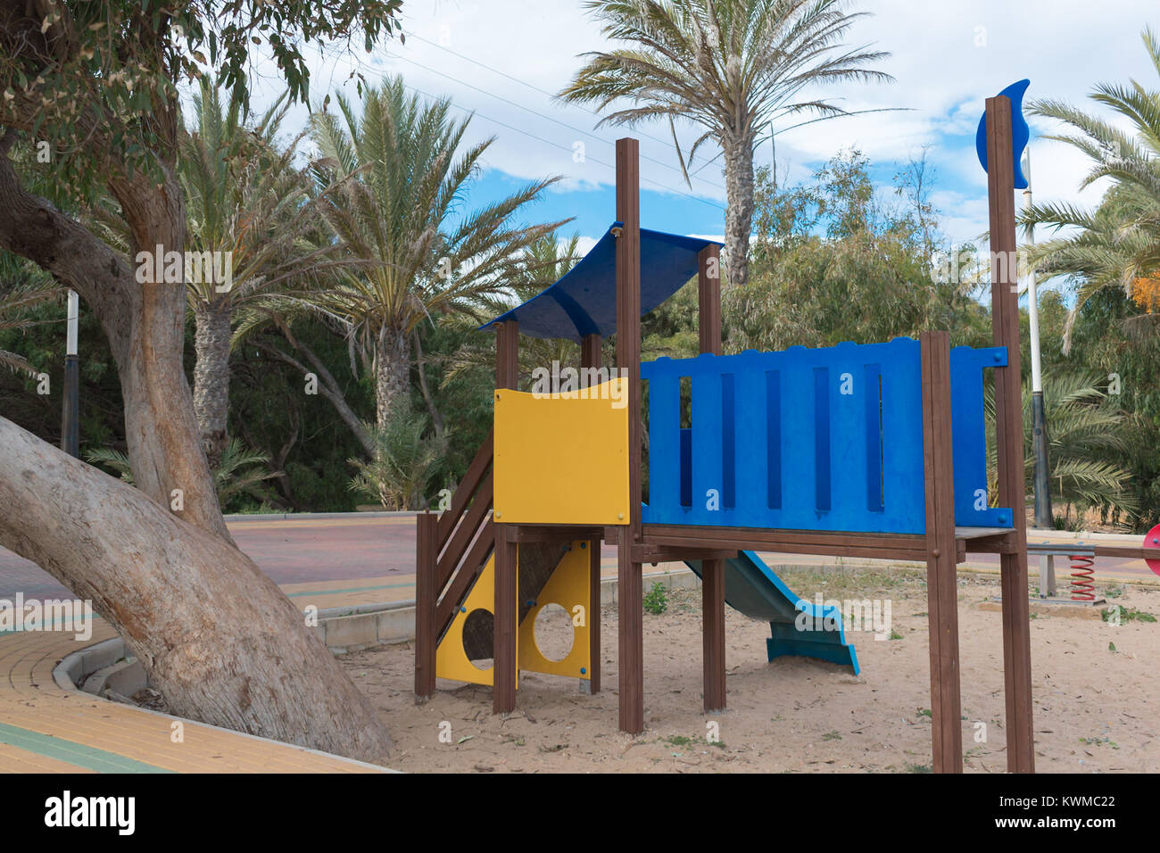 Yellow and blue park play equipment for childrens with palmtrees ...