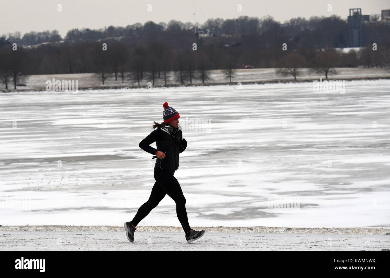 Washington, USA. 4th Jan, 2018. A woman runs by the frozen Potomac ...
