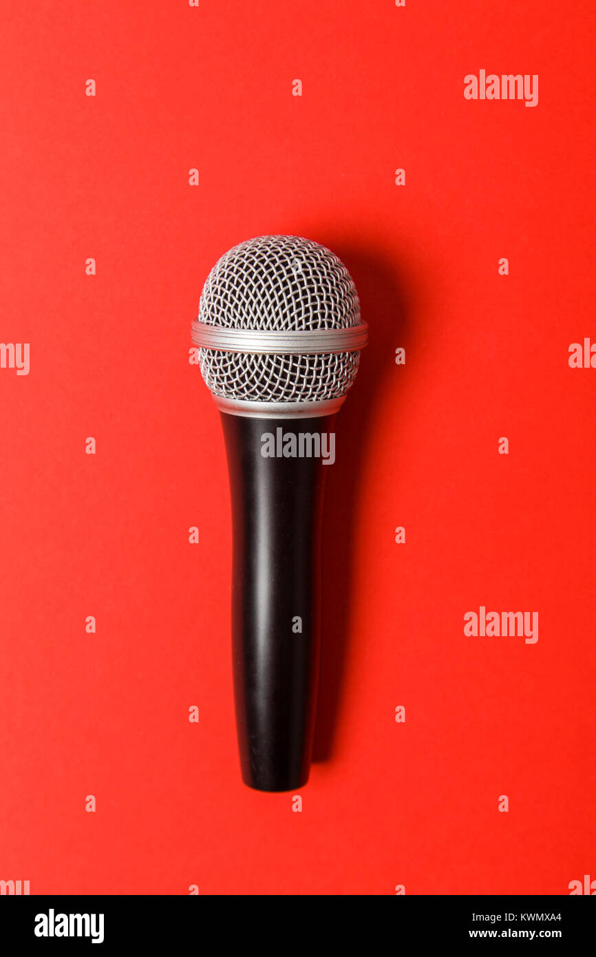 microphone on a bright red background Stock Photo - Alamy