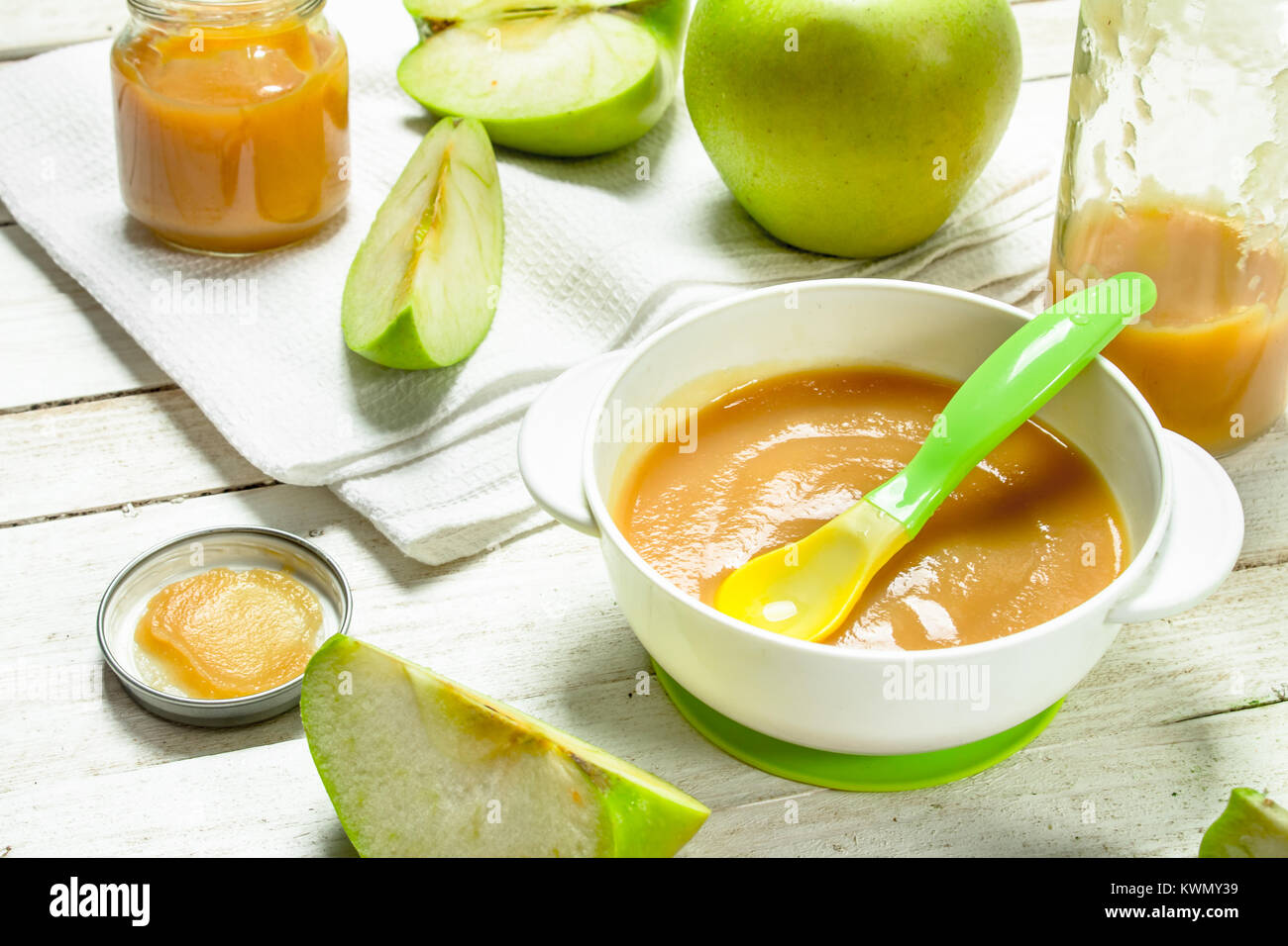 Baby food. Baby puree from fresh green apples. On a white wooden ...