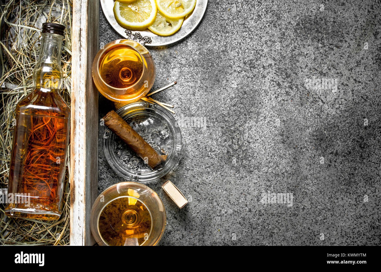 Cognac background. A bottle of cognac with lemon and a cigar. On a ...