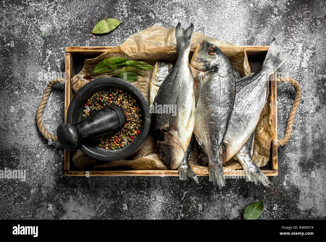 resh Dorado fish with spices on an old tray. On a rustic background ...