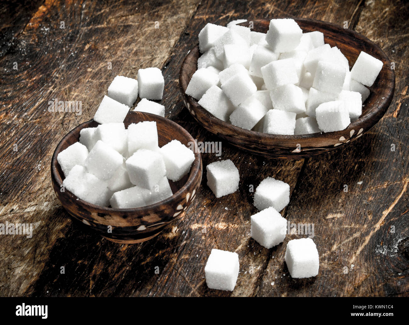 Cubes of sugar in a bowl. On a wooden background Stock Photo - Alamy
